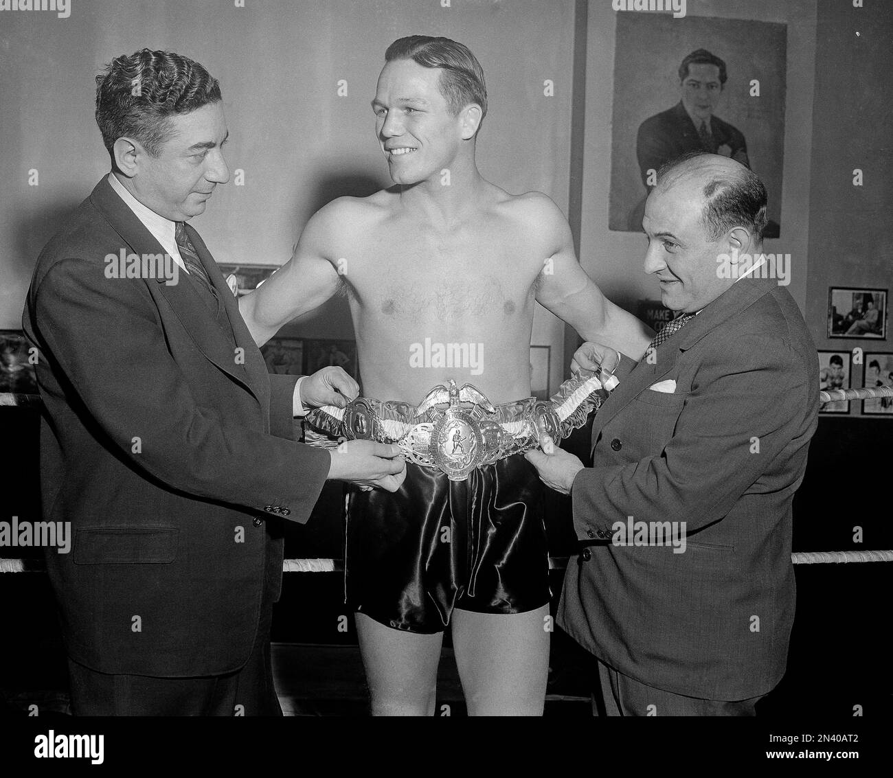 Tony Zale, center, of Gary, Ind., dons the world championship ...