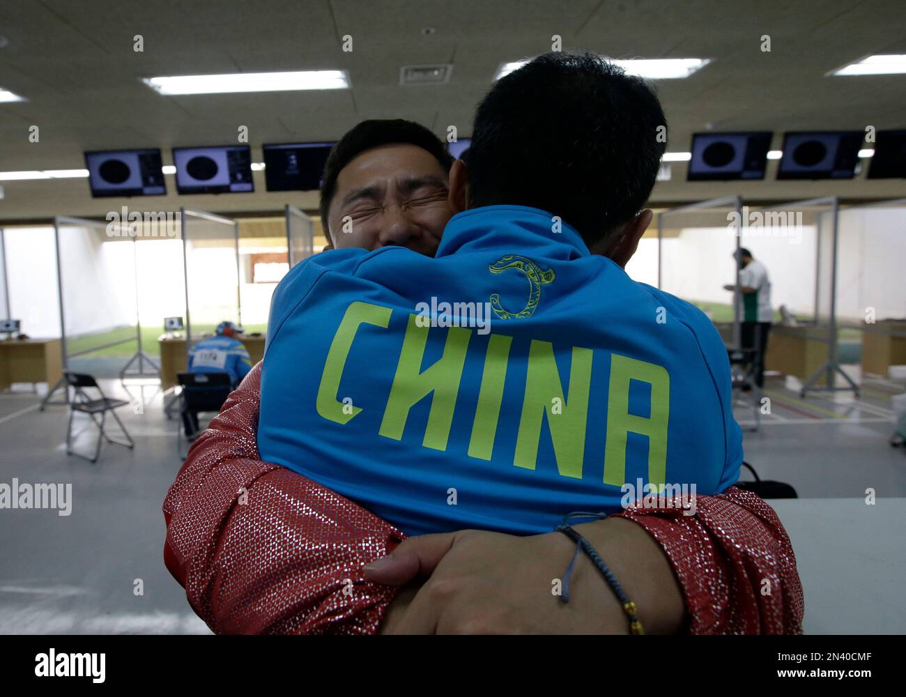 China's Ding Feng celebrates with his coach Zhang Jianwei after winning ...