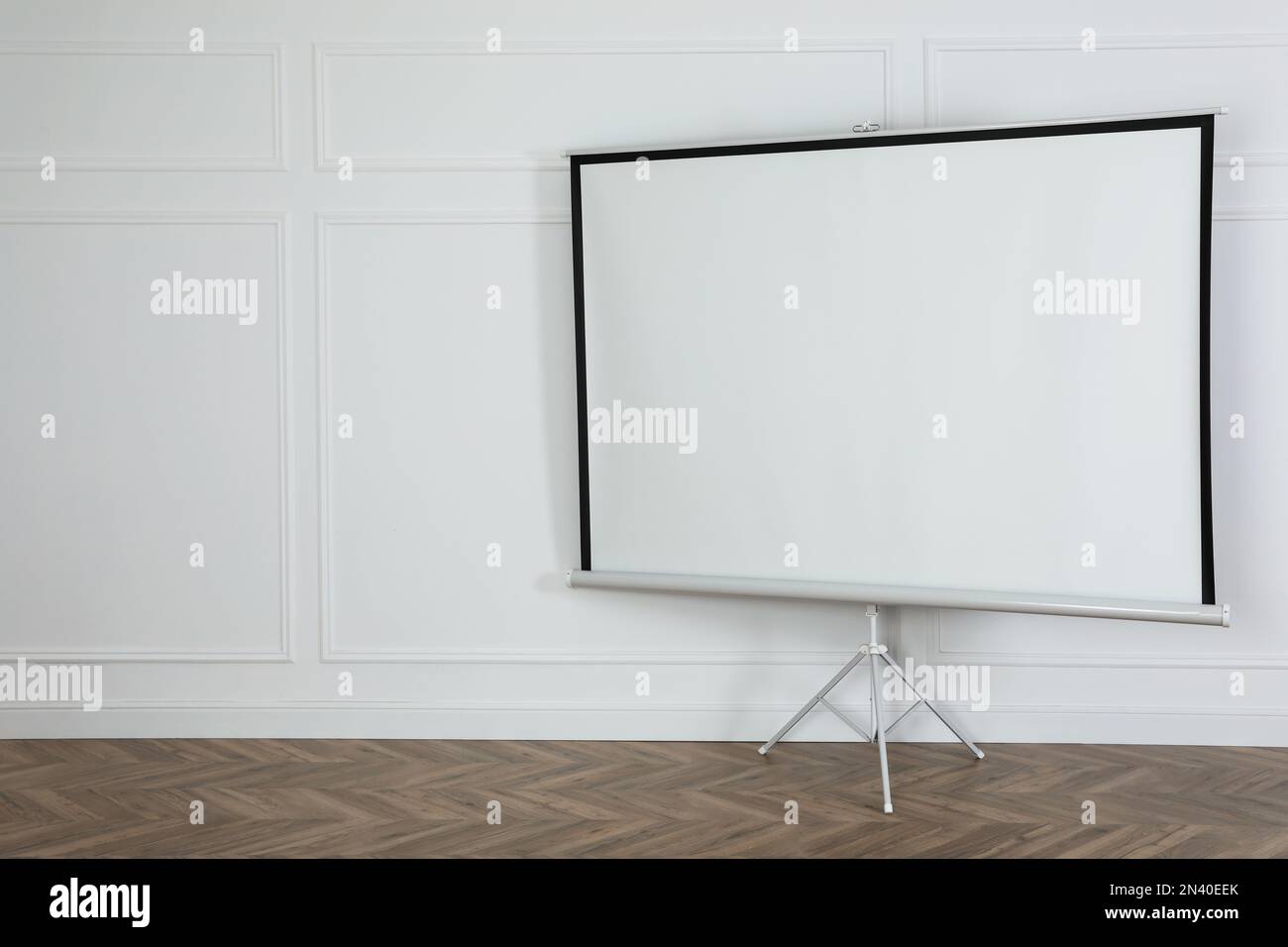 Blank projection screen near white wall indoors. Space for design Stock ...