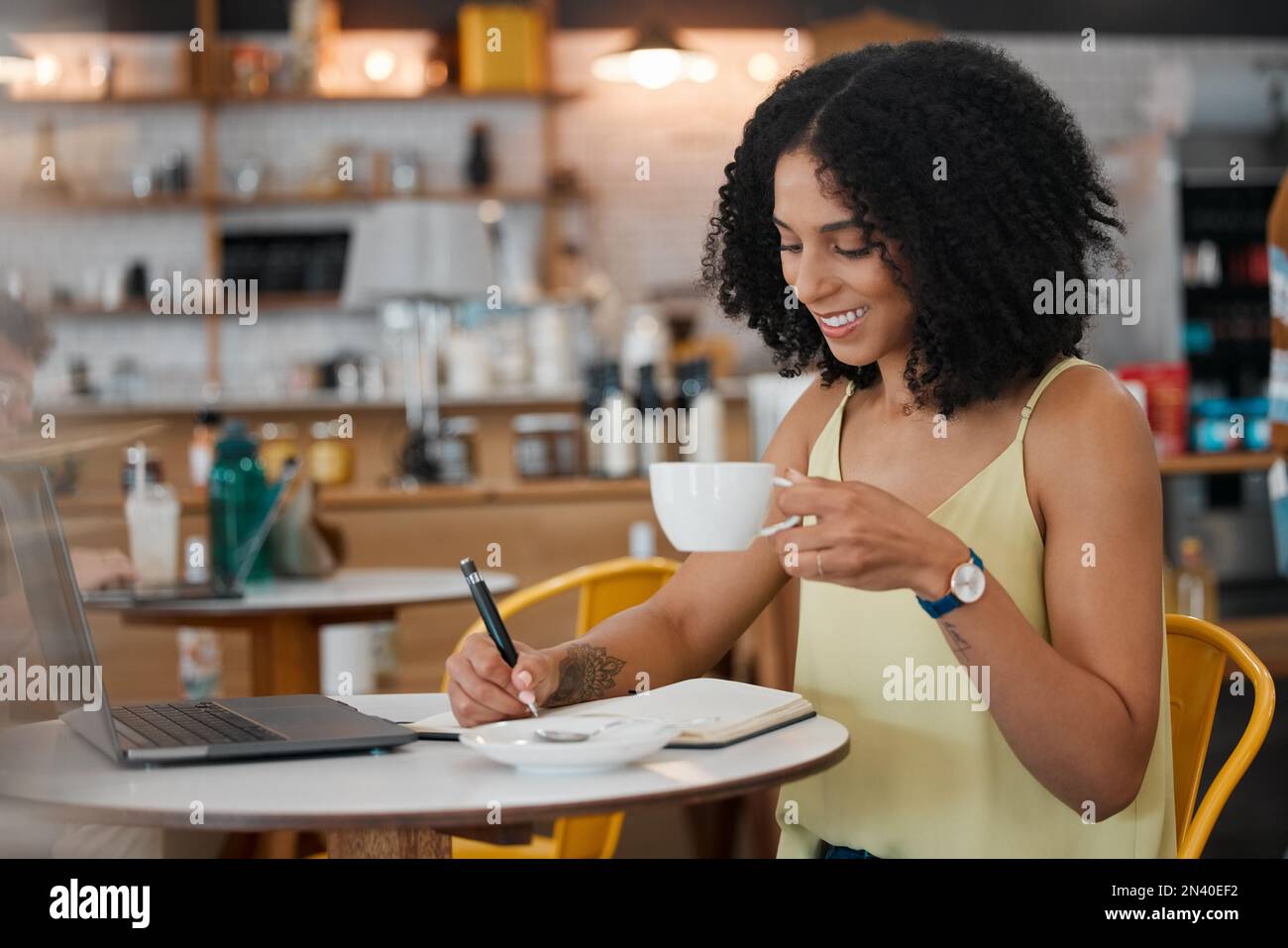Coffee shop, laptop and woman writing notes for a freelance project ...