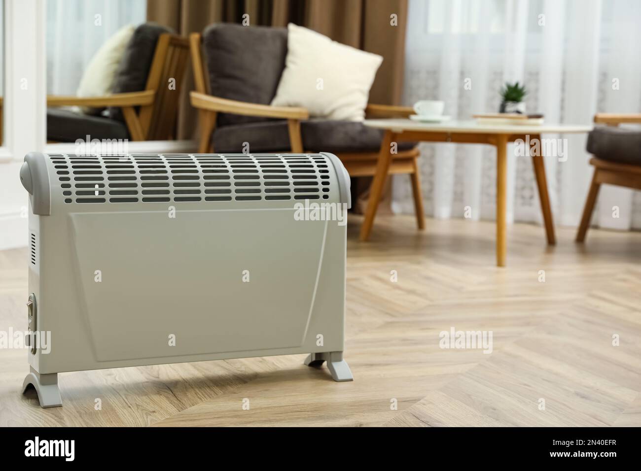 Modern electric convection heater on floor at home. Space for text ...