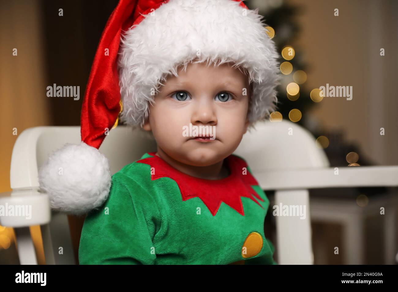 Baby in cute elf costume sitting on chair at home. Christmas outfit ...