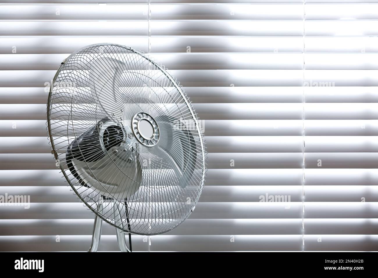 Modern electric fan near window indoors. Space for text Stock Photo - Alamy