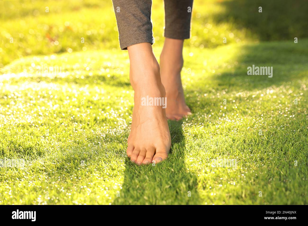 Young woman walking barefoot on fresh green grass, closeup Stock Photo ...