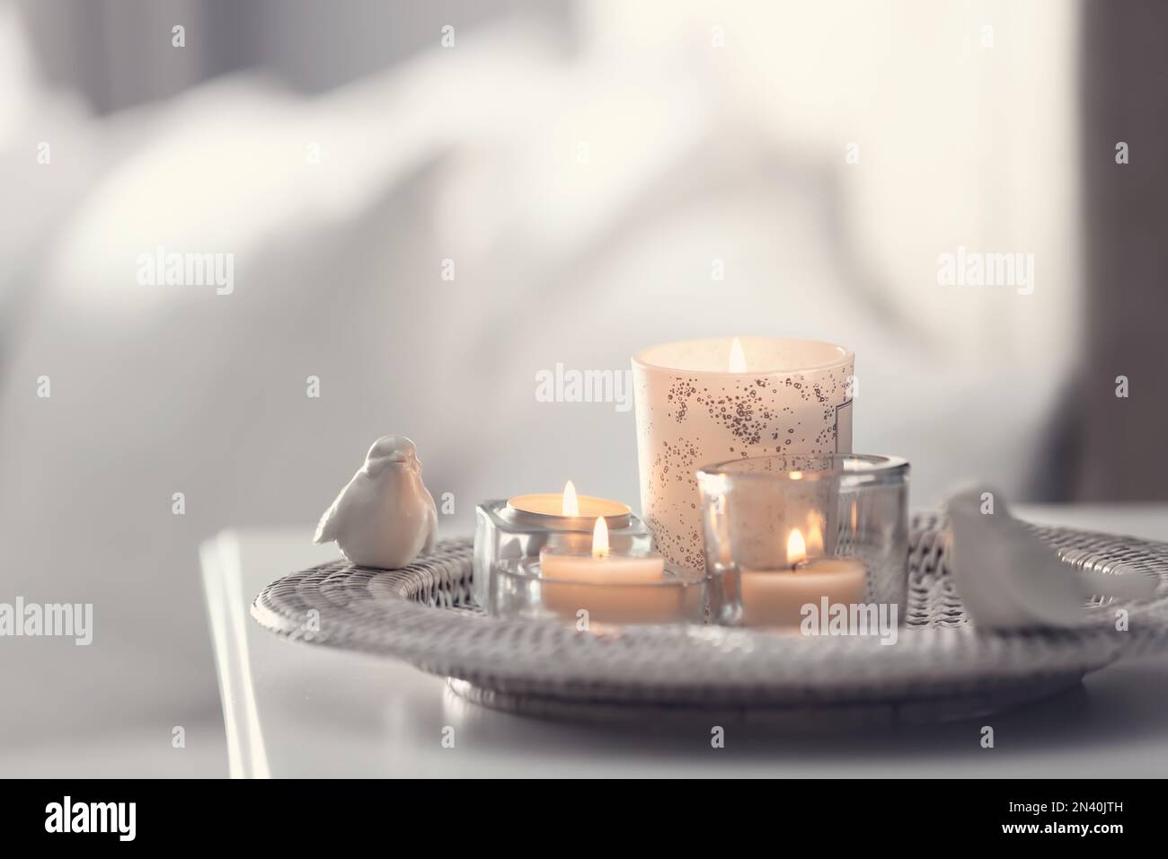Beautiful burning candles on tray against light background Stock Photo ...