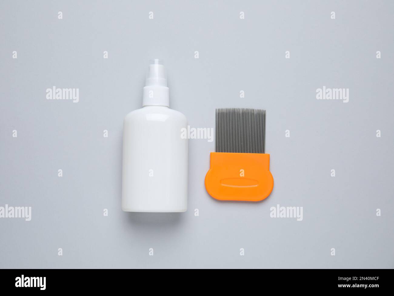 Spray and metal comb for anti lice treatment on light grey background ...
