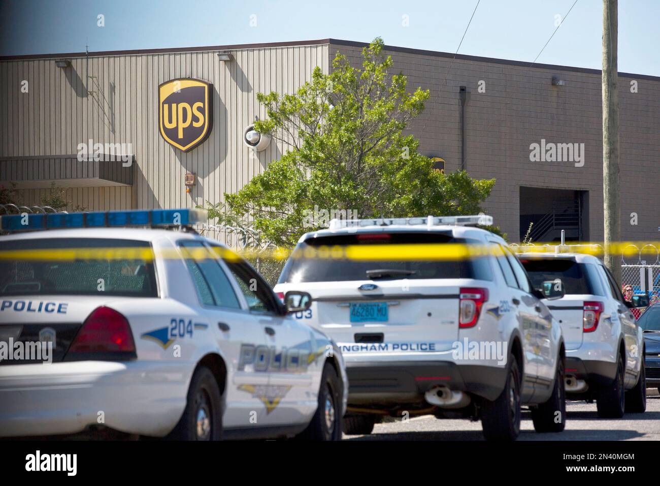 A UPS warehouse has police cars and tape surrounding it on Tuesday ...