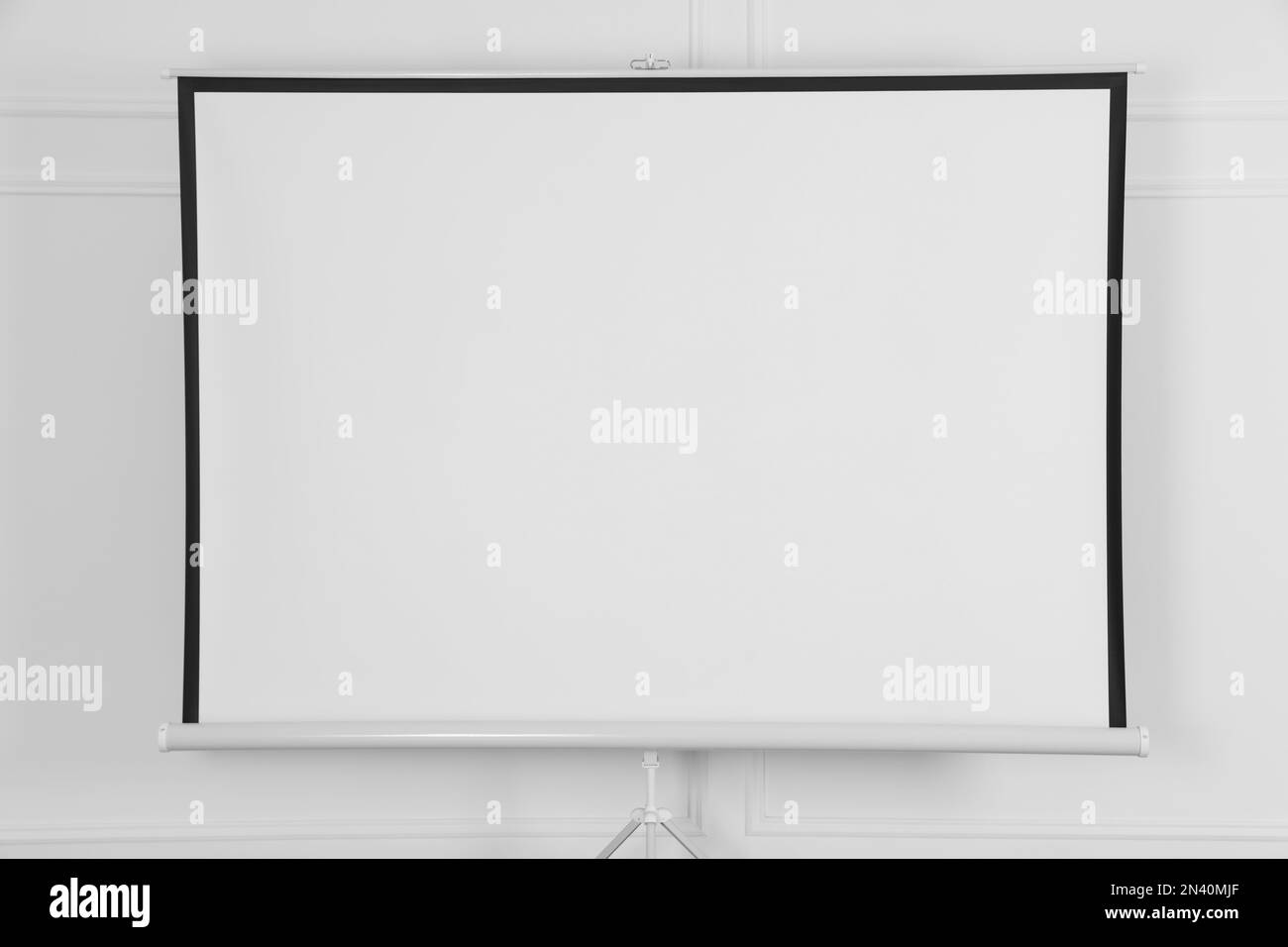 Blank projection screen near white wall indoors. Space for design Stock ...