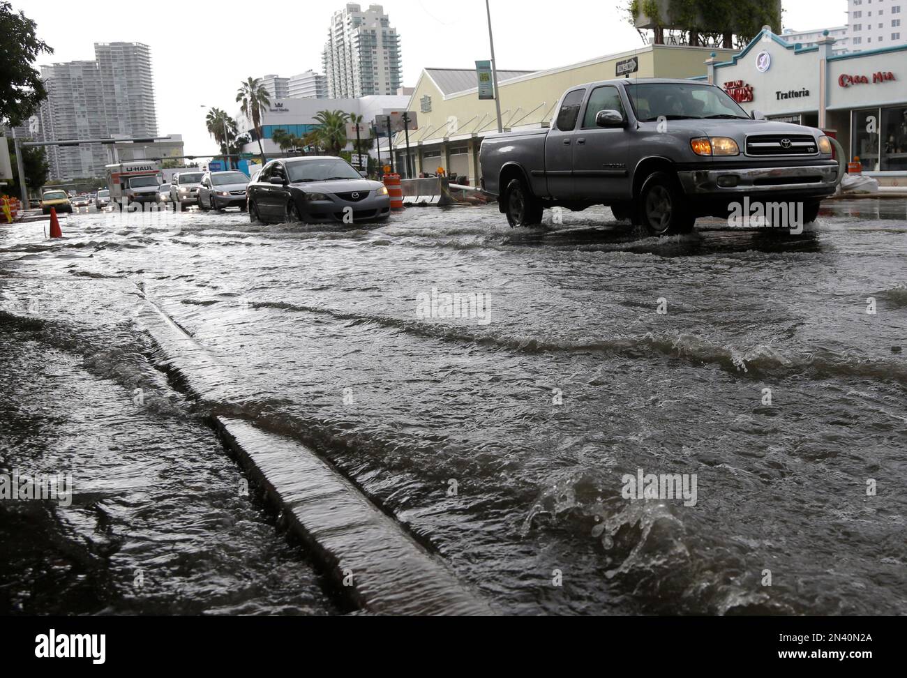 Vehicles negotiate heavily flooded streets as rain falls, Tuesday, Sept ...