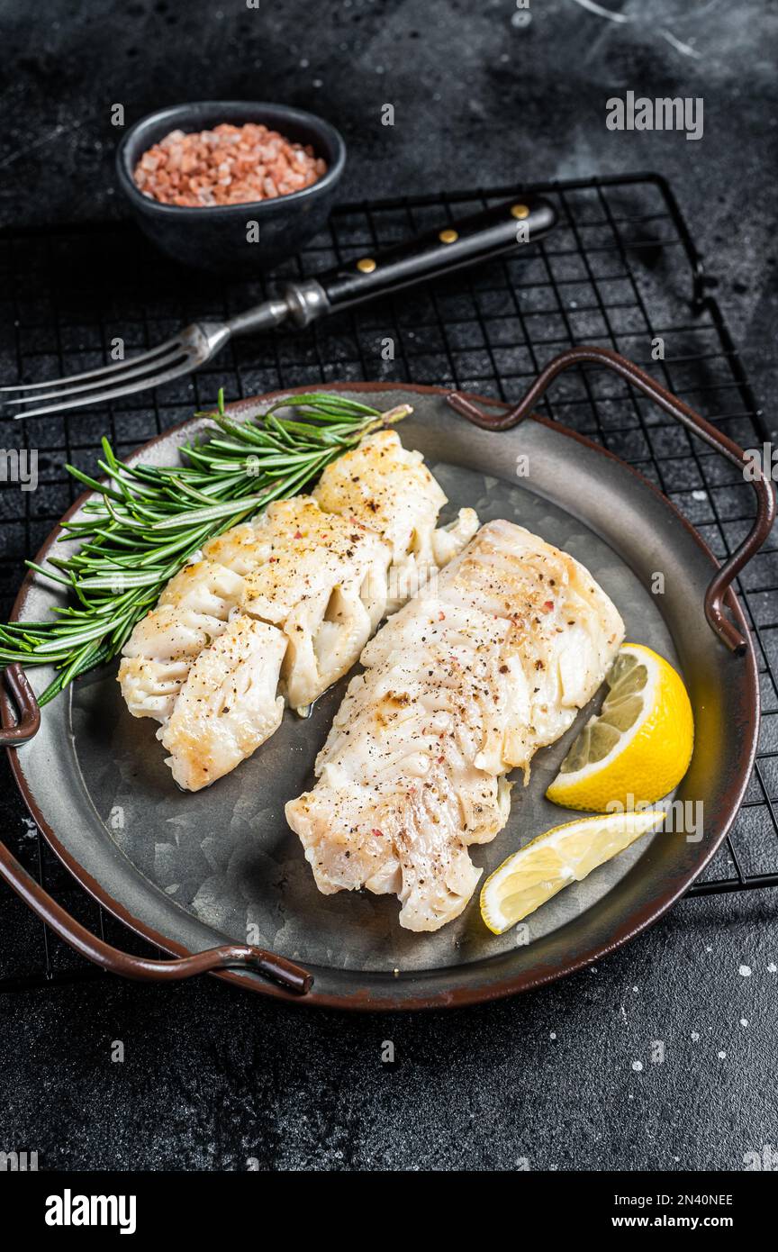 Roast Fillets of codfish, cooked cod fish meat. Black background. Top ...