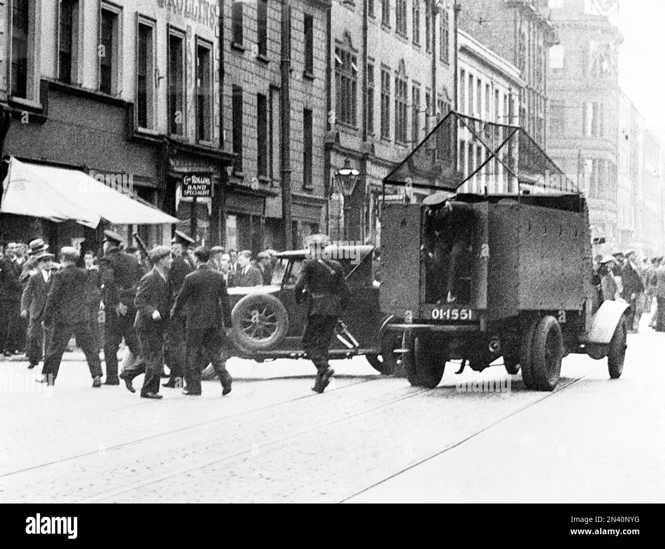 Police armed with rifles descending from an armoured car to pursue ...