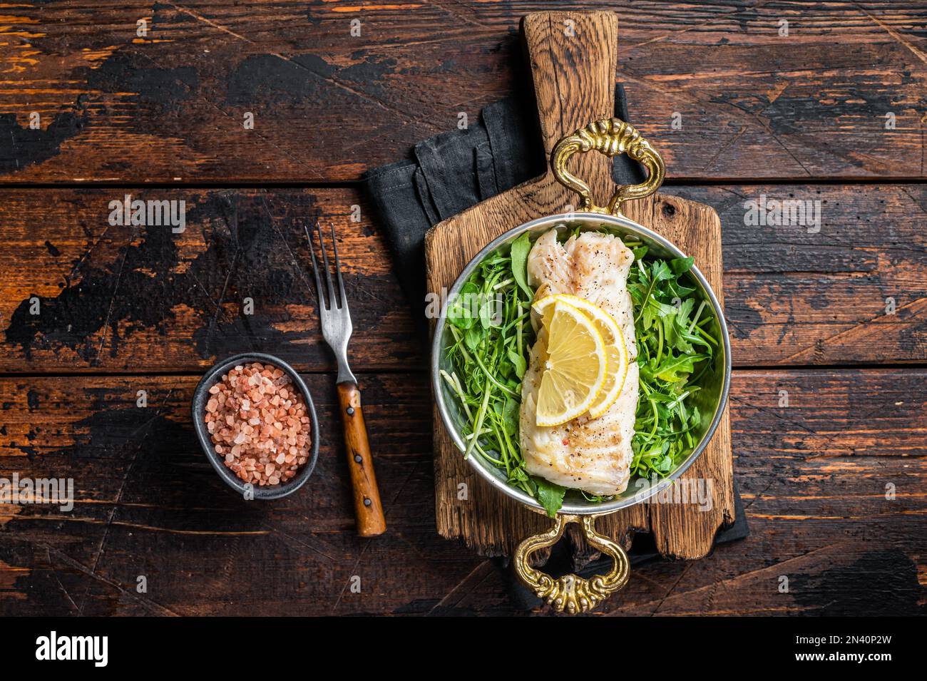 Roasted pollock or coalfish fish fillet served with green salad in a ...