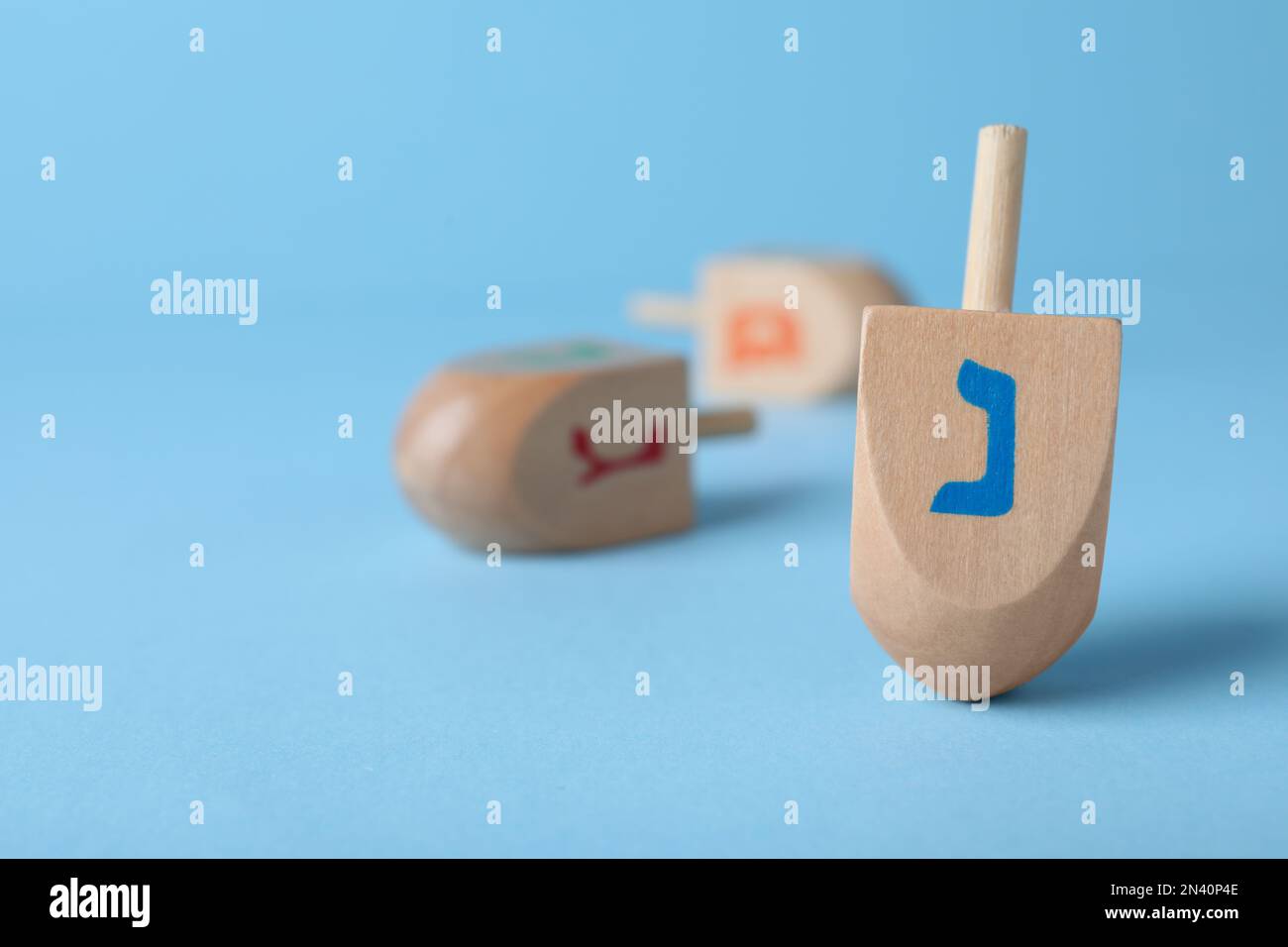 Hanukkah traditional dreidel with letter Nun on light blue background ...