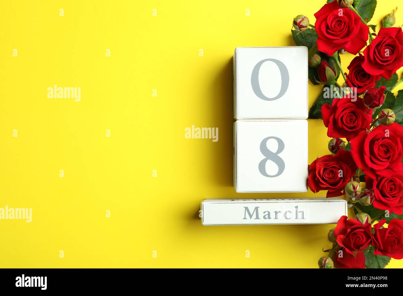 Wooden block calendar with date 8th of March and roses on yellow ...
