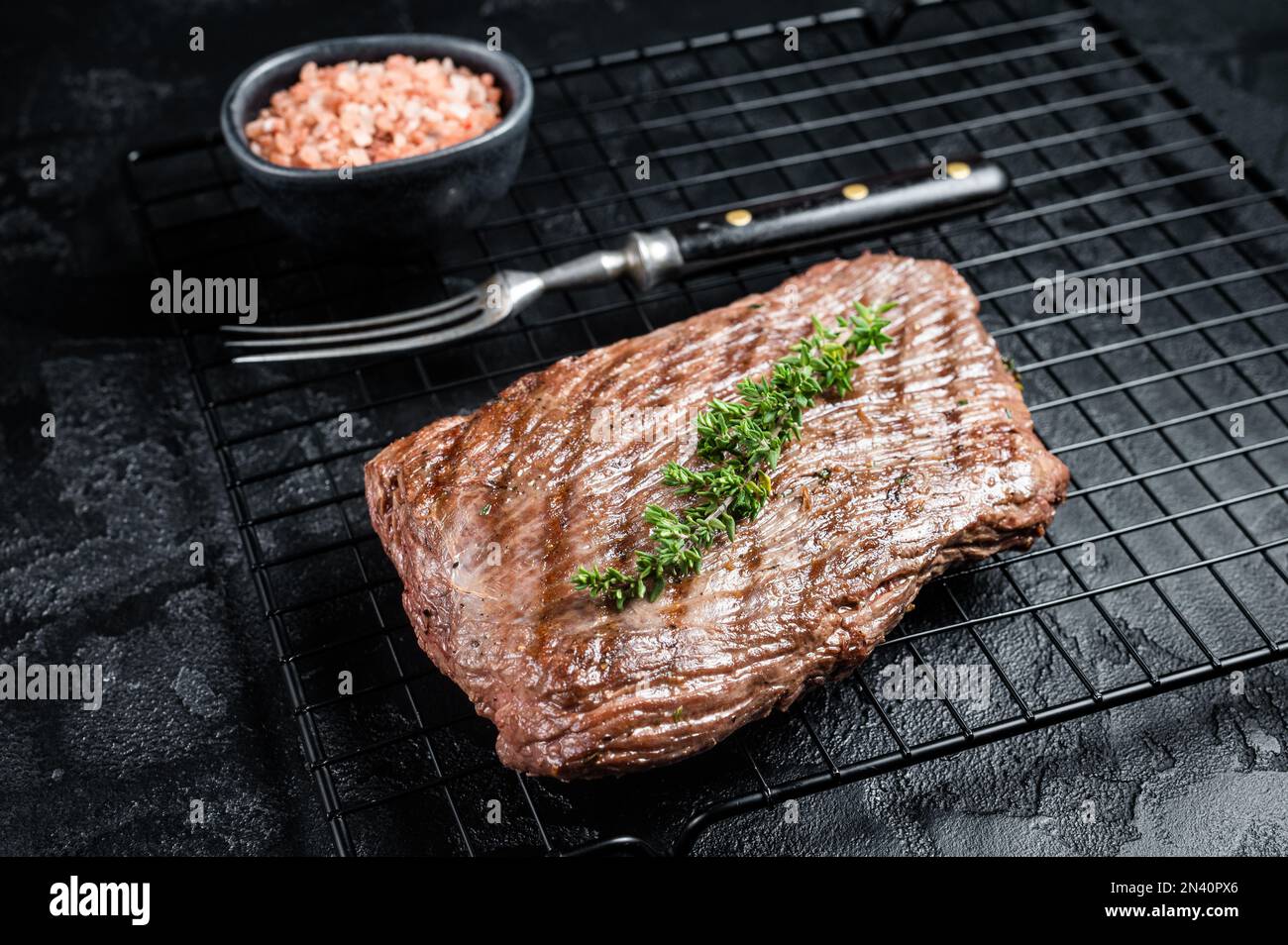 Roasted medium rare flank beef steak with thyme. Black background. Top ...