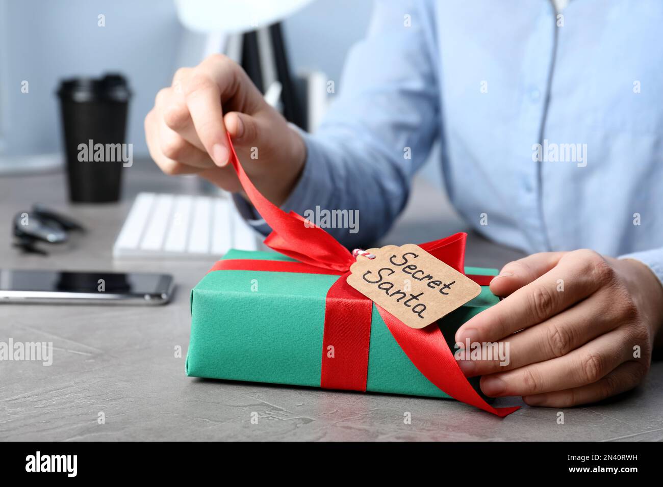 Man opening present from secret Santa at workplace, closeup Stock Photo ...