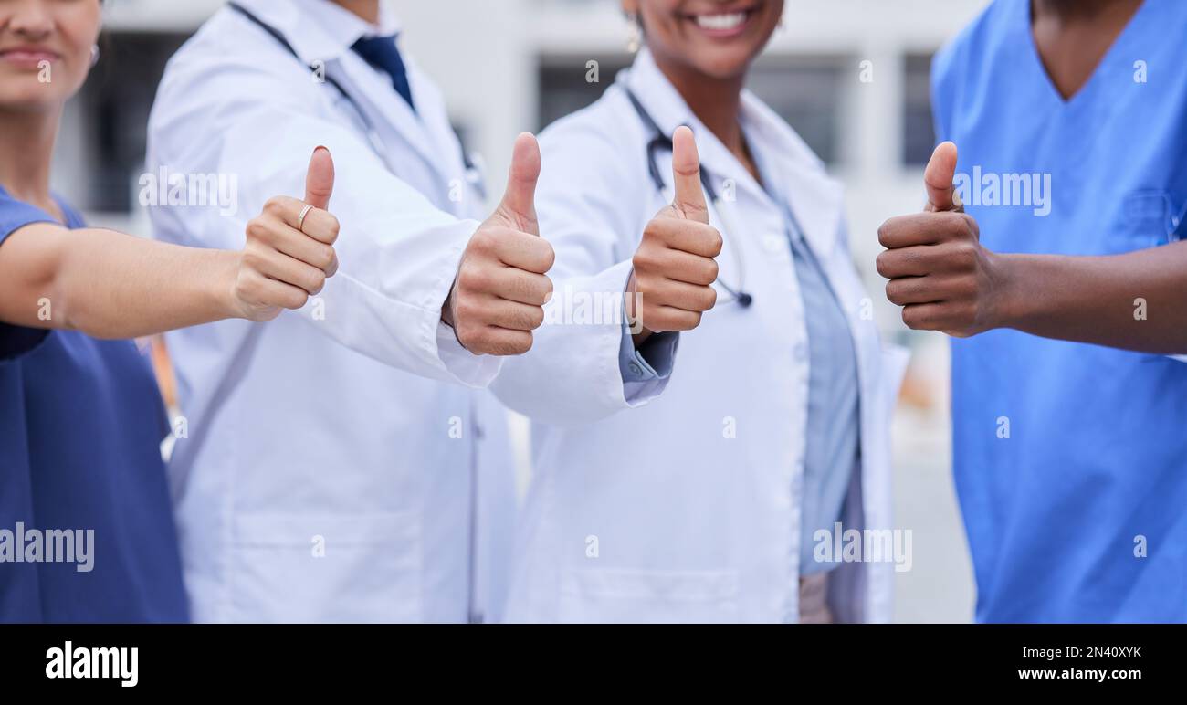 Doctor, thumbs up and medical teamwork with hands, smile or support for ...