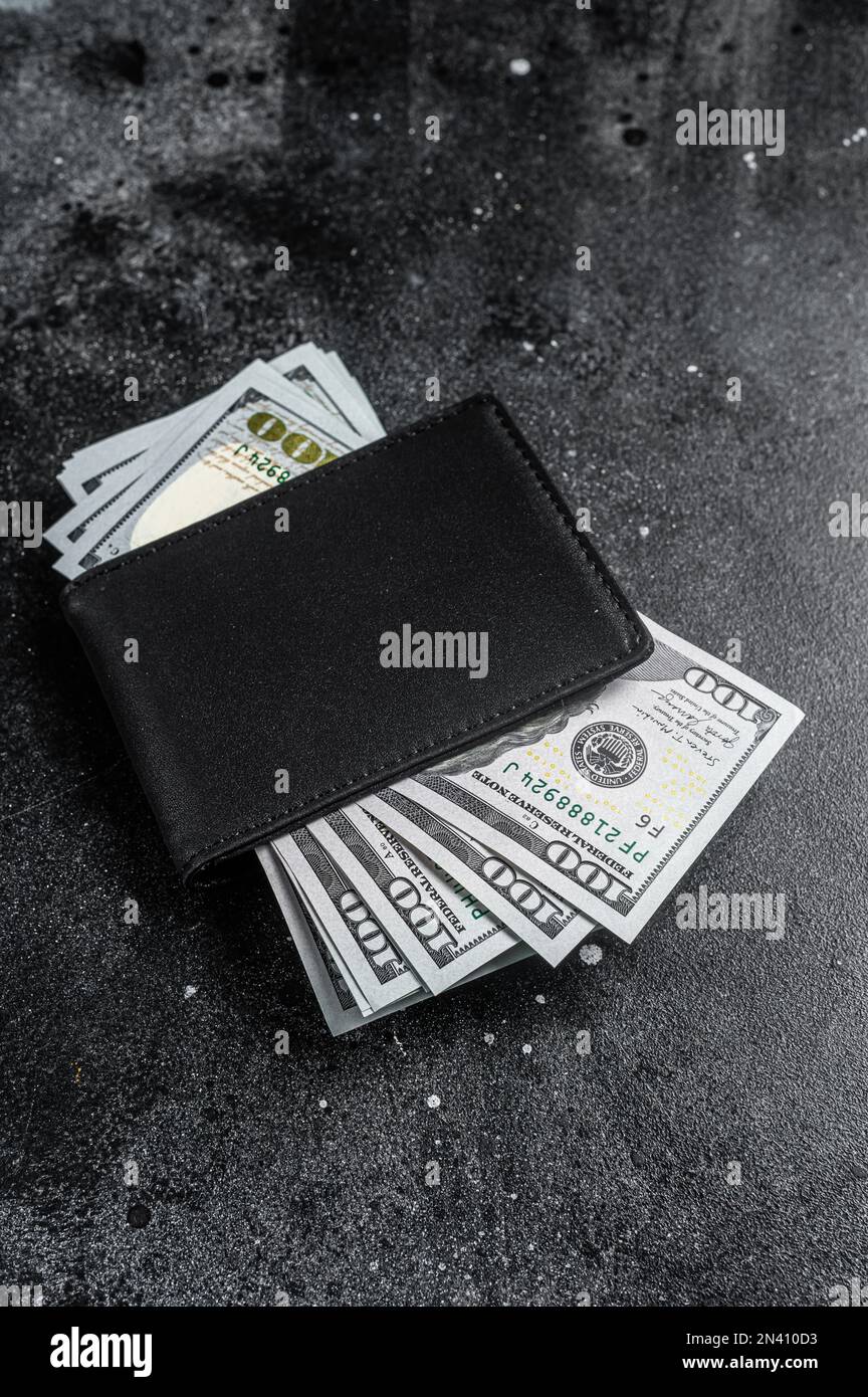 One black purse with the big pack of dollars, Cash of dollar note ...