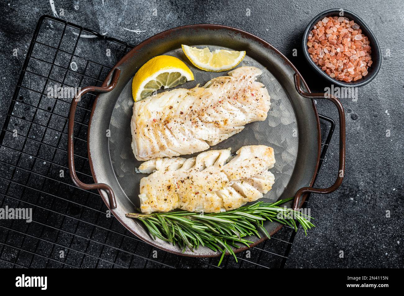 Roast Fillets of codfish, cooked cod fish meat. Black background. Top ...