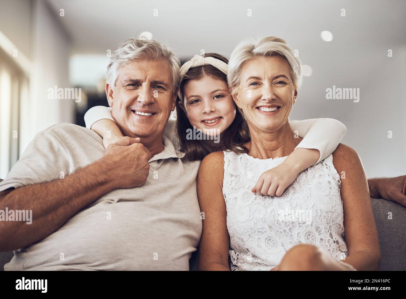 Relax, portrait or grandparents hug a girl in living room bonding as a ...