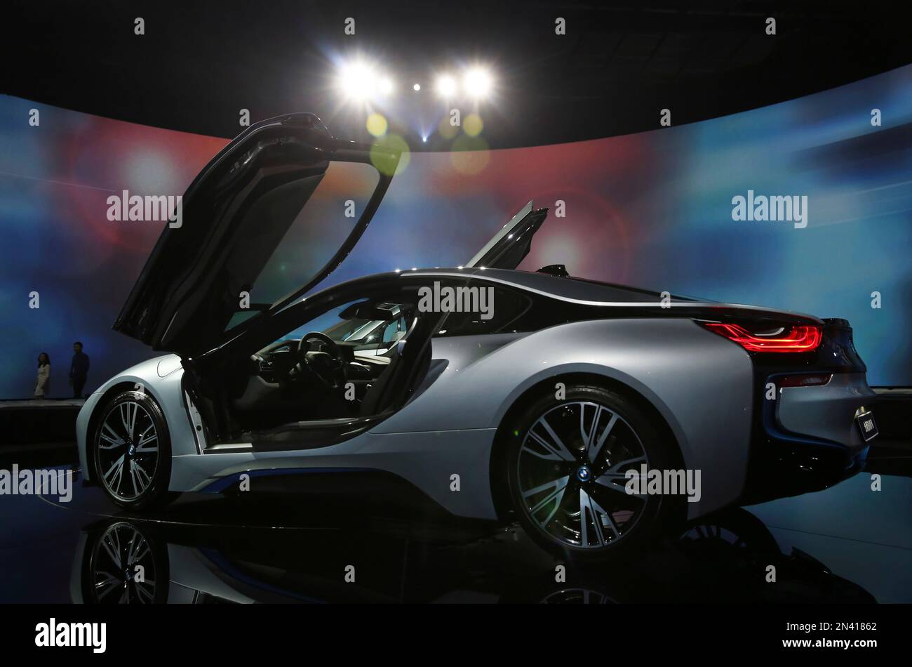 Invited guests walk past a BMW i8 electric car model on display after its official launch by ...