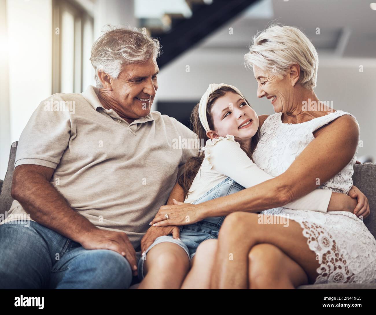 Relax, happy or grandparents hug a girl in living room bonding as a ...