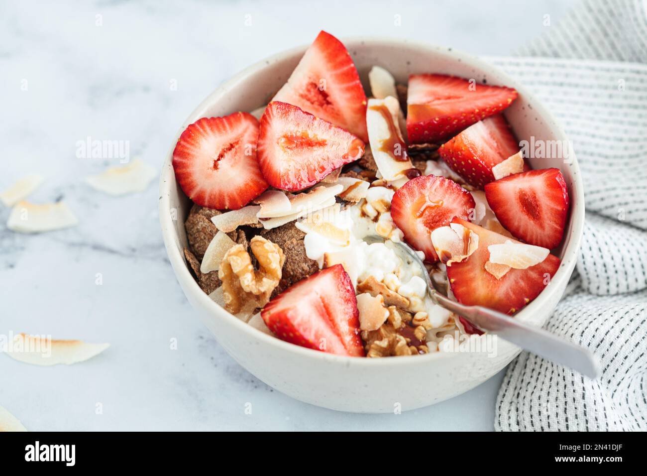 Cottage cheese bowl with strawberries, cereal flakes, coconut, nuts and ...