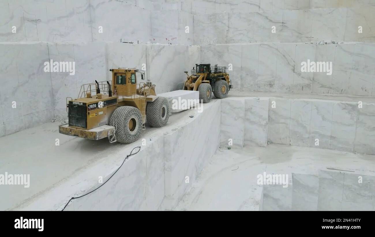 Wheel loaders working on huge marble quarry Stock Photo - Alamy