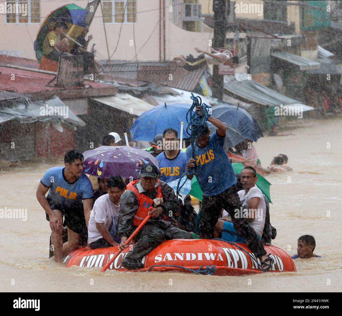 A man dives in the background as rescuers use a rubber dinghy to rescue ...