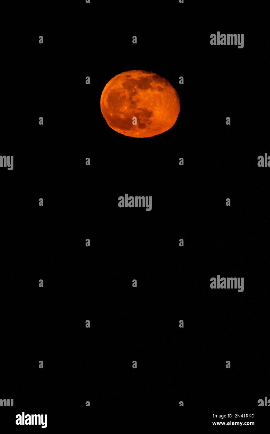 A 98% waning gibous moon, distorted and coloured red in the atmosphere ...