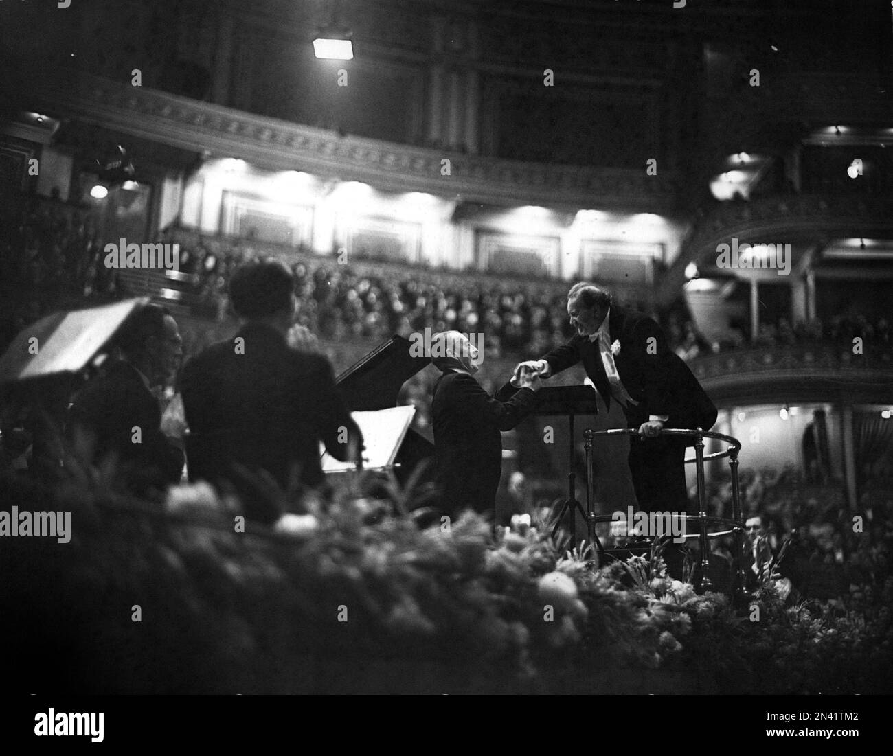 Conductor Sir Henry Wood shaking hands from the podium with Sergei ...