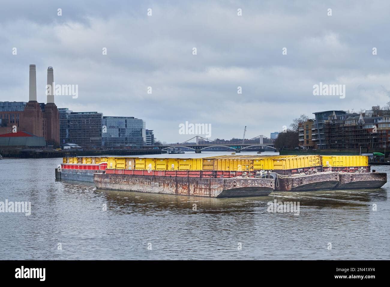 Barges, loaded with containers of rubbish, moored on the river Thames ...