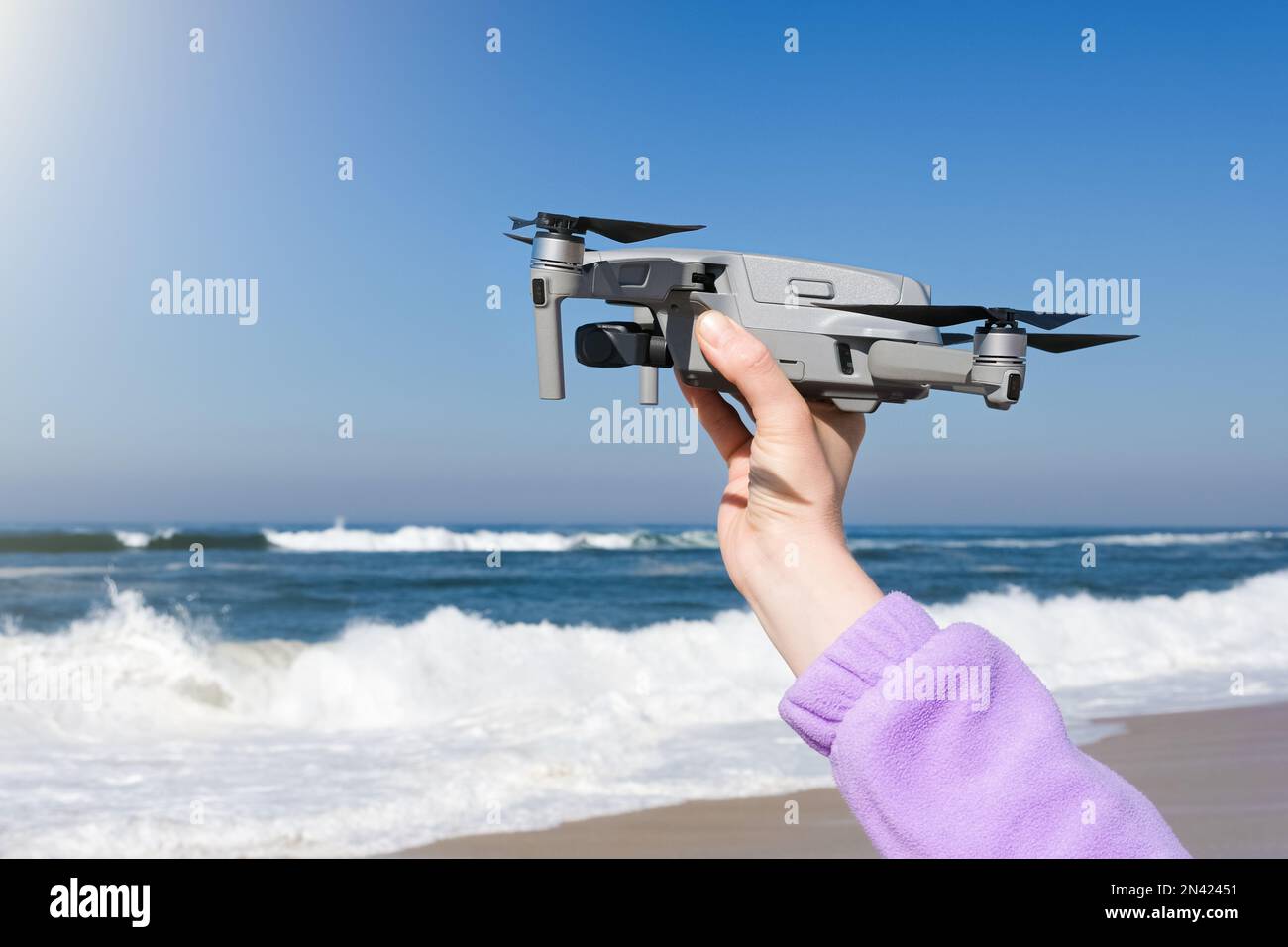 Hand holding drone ready to take off on the background of stormy ...
