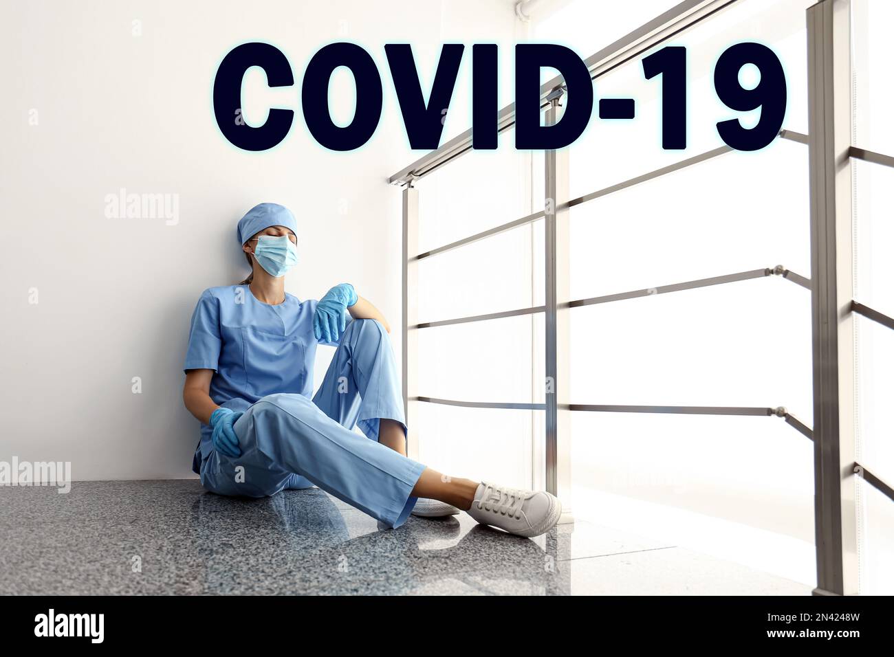 Tired overwhelmed nurse sitting on floor in hospital. Medical system ...