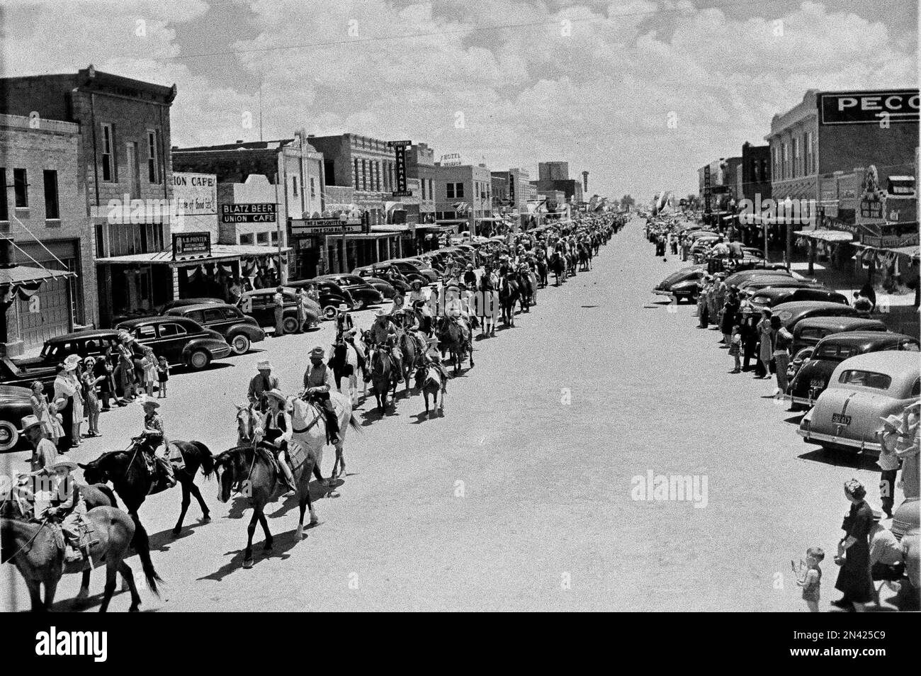 The grand parade of cowboys takes place on Main Street on Pecos, Texas ...