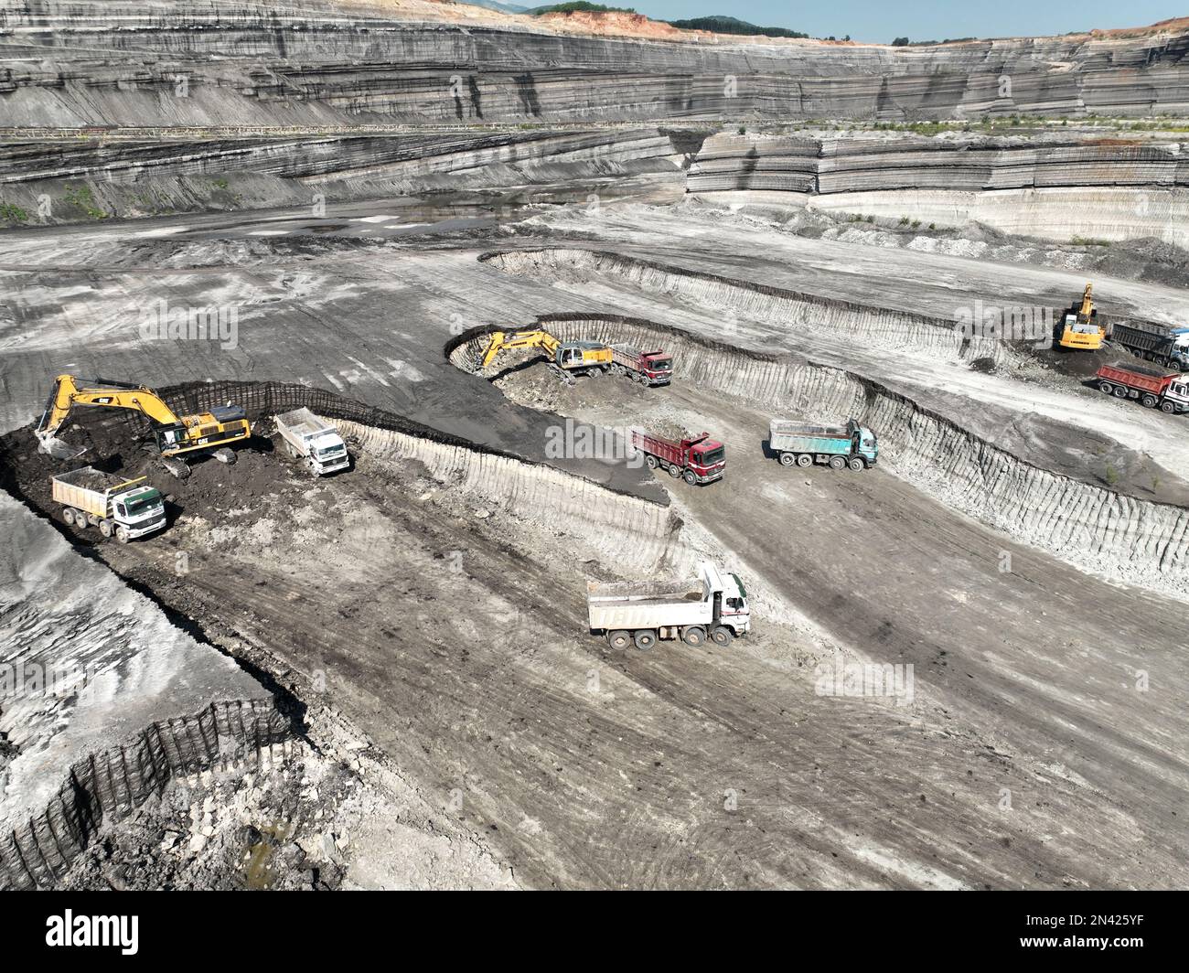 Excavators working. Loading trucks on huge mining site Stock Photo - Alamy