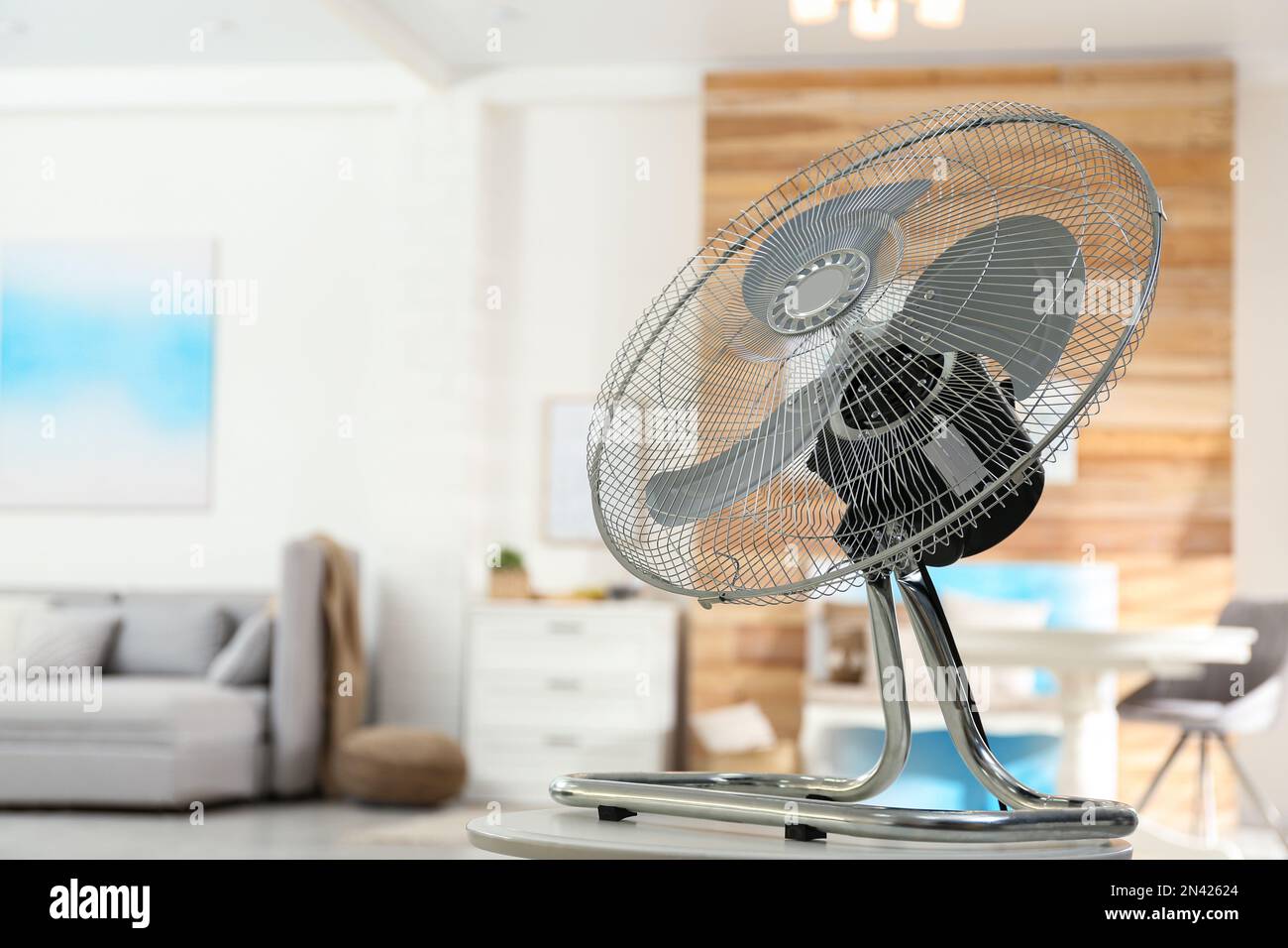 Modern electric fan on white table in living room. Space for text Stock ...