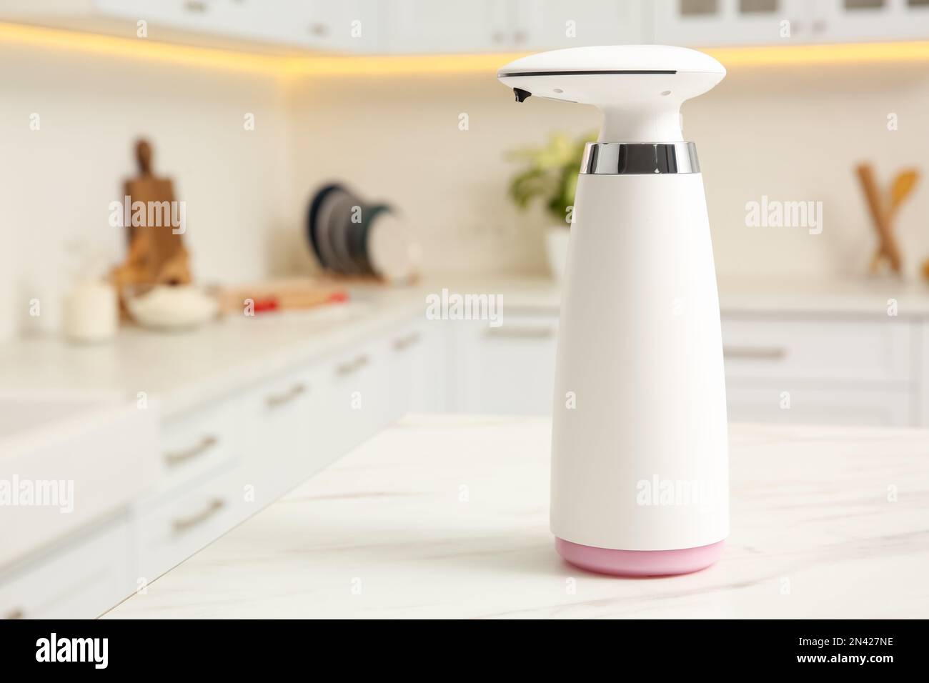 Modern automatic soap dispenser on countertop in kitchen. Space for ...