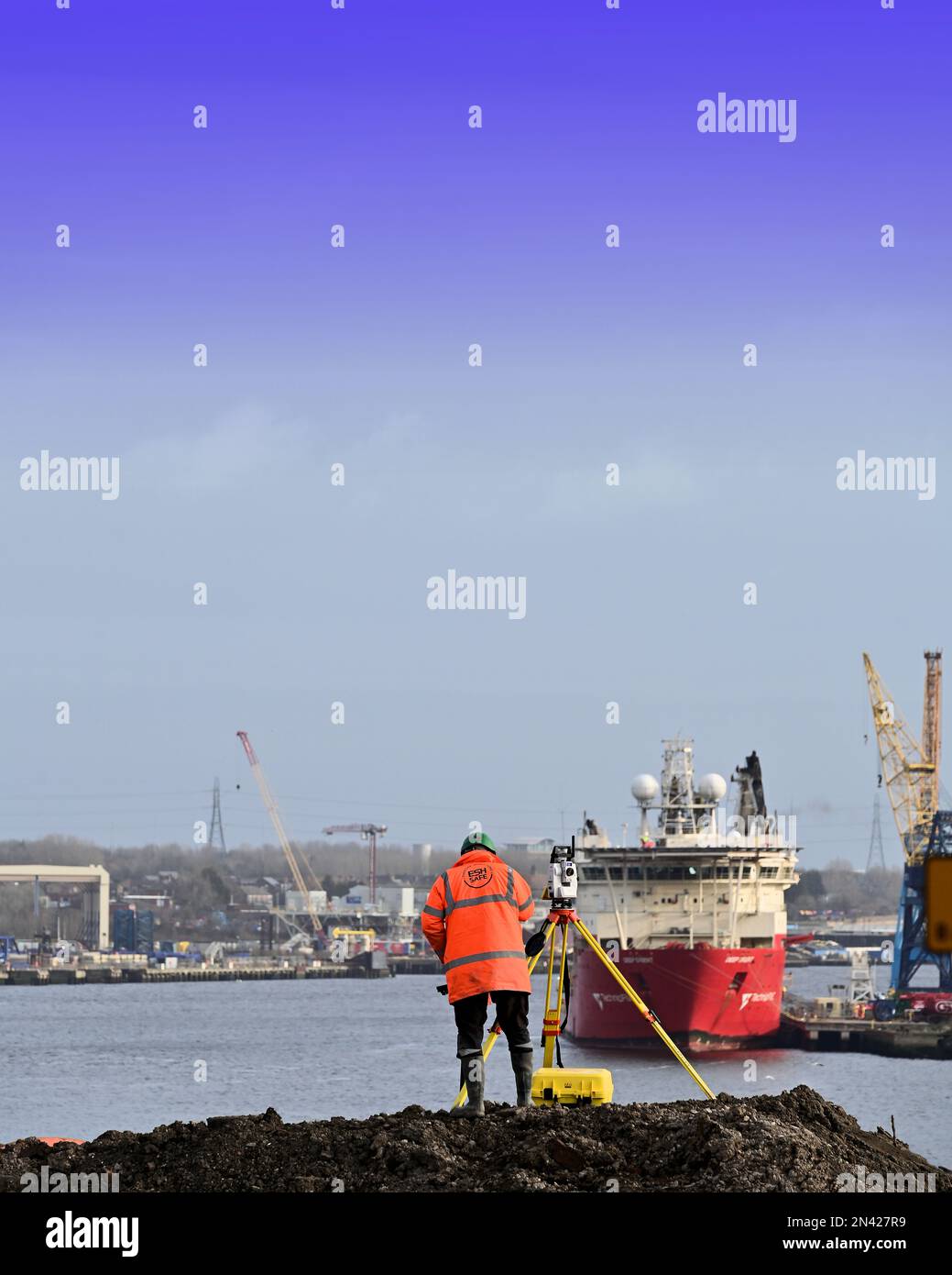 A surveyor using a theodolite to landscape the area before developing ...