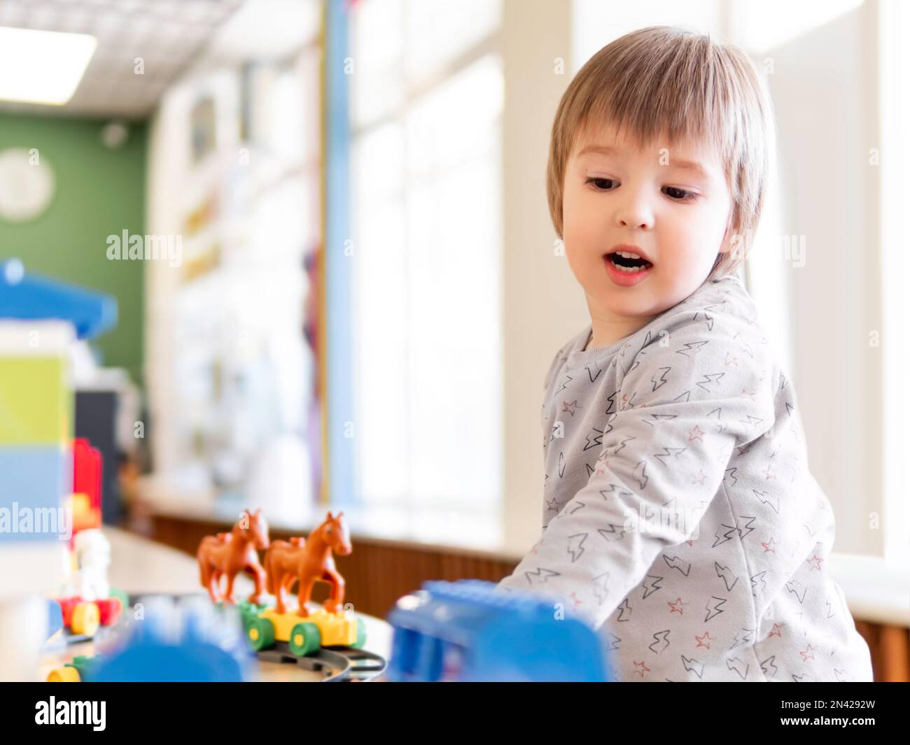 Toddler plays with colorful toy blocks. Little boy stares on figure ...