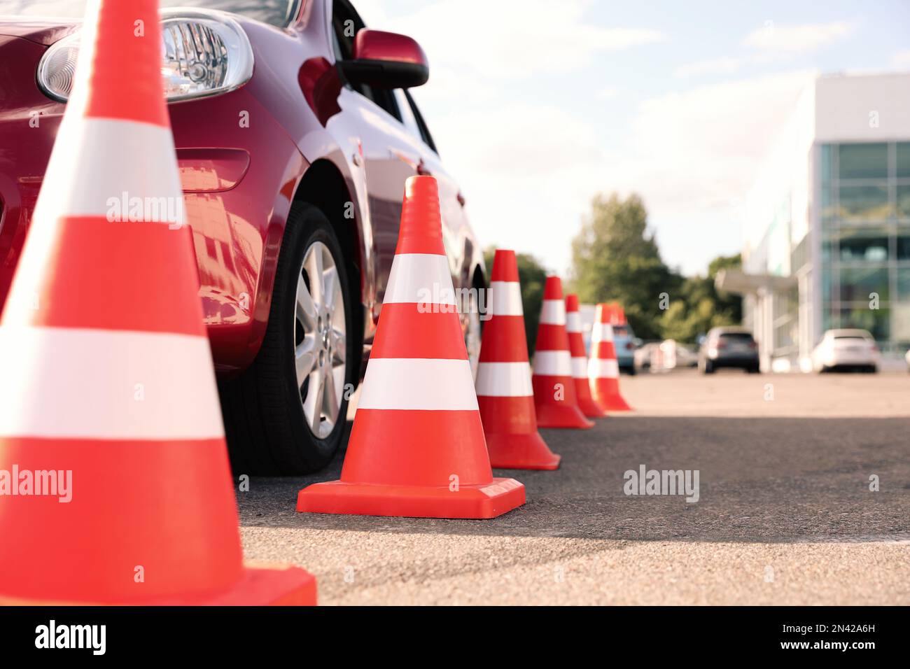 Traffic cones near red car outdoors. Driving school exam Stock Photo ...