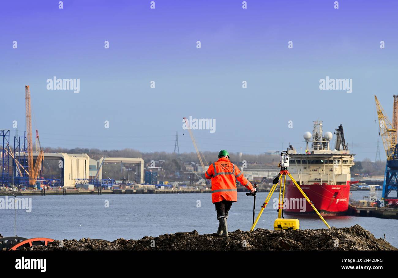 A surveyor using a theodolite to landscape the area before developing ...