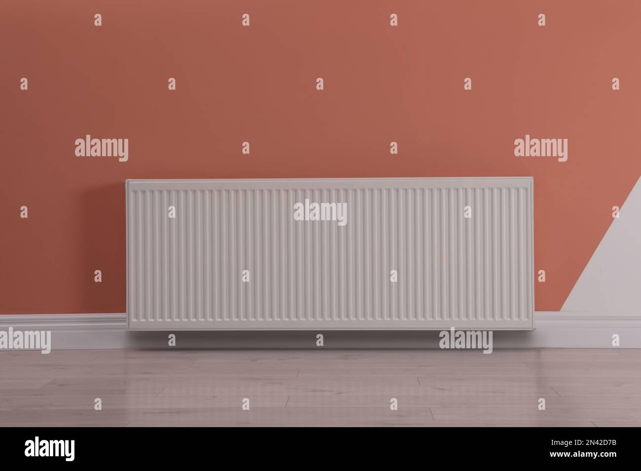 Modern radiator on color wall. Central heating system Stock Photo - Alamy