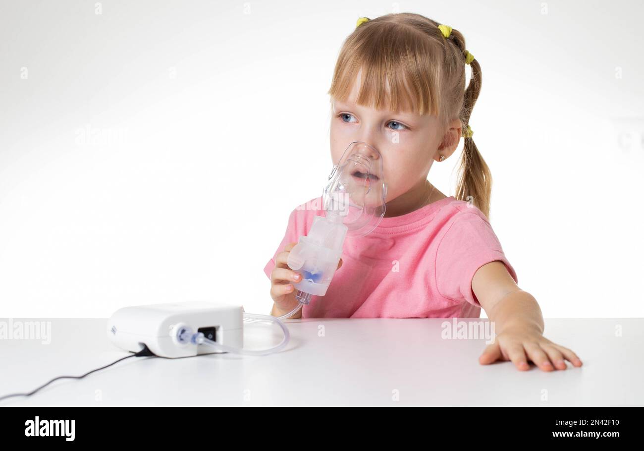 Beautiful little girl breathing into an inhaler for asthma and ...