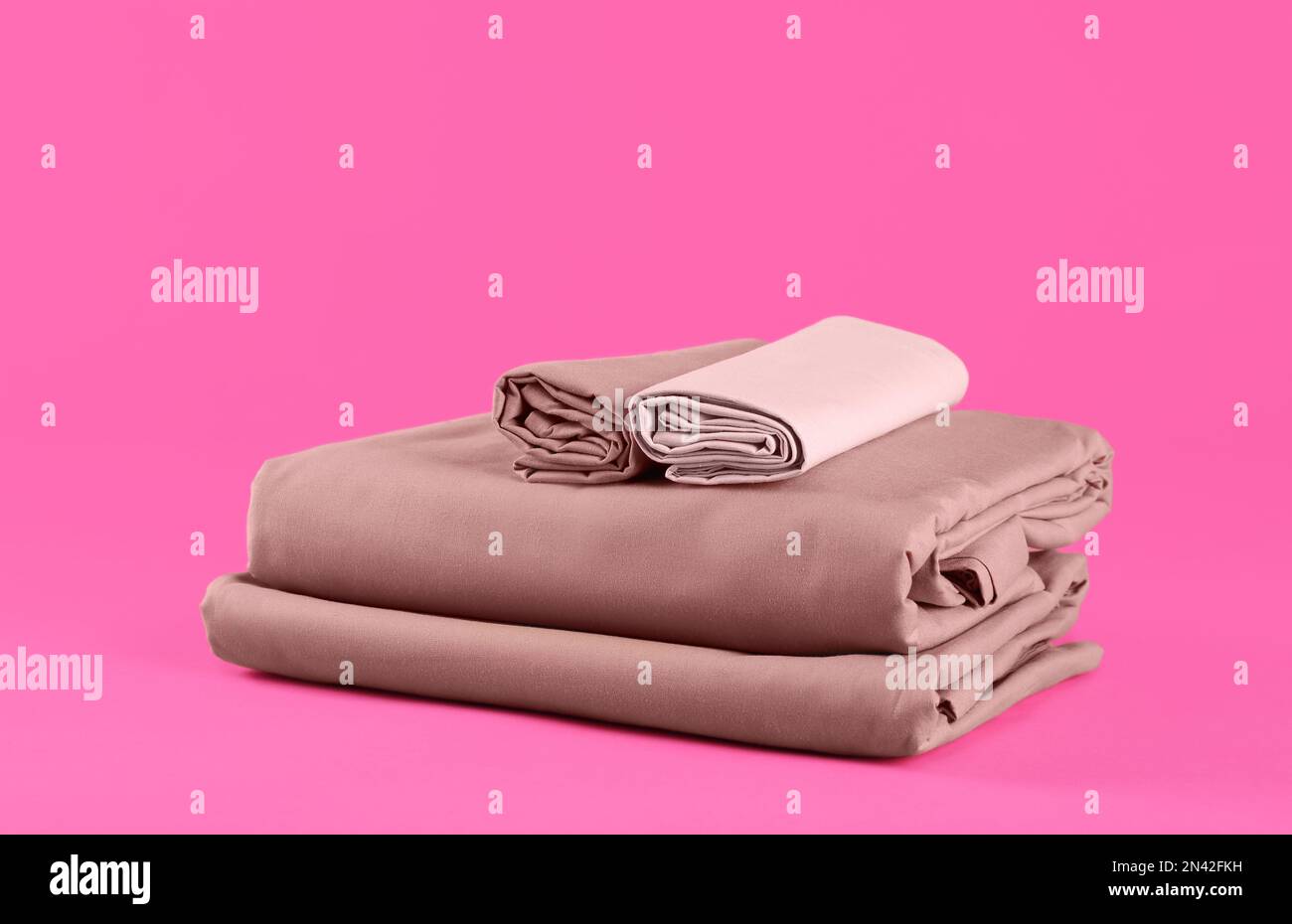 Stack of clean bed sheets on pink background Stock Photo - Alamy