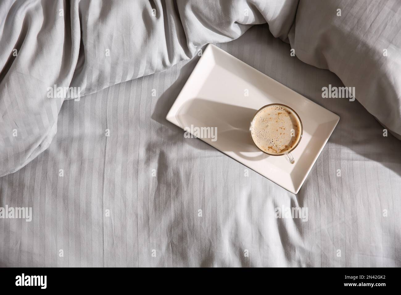 Tray with morning coffee on soft blanket, top view. Space for text ...