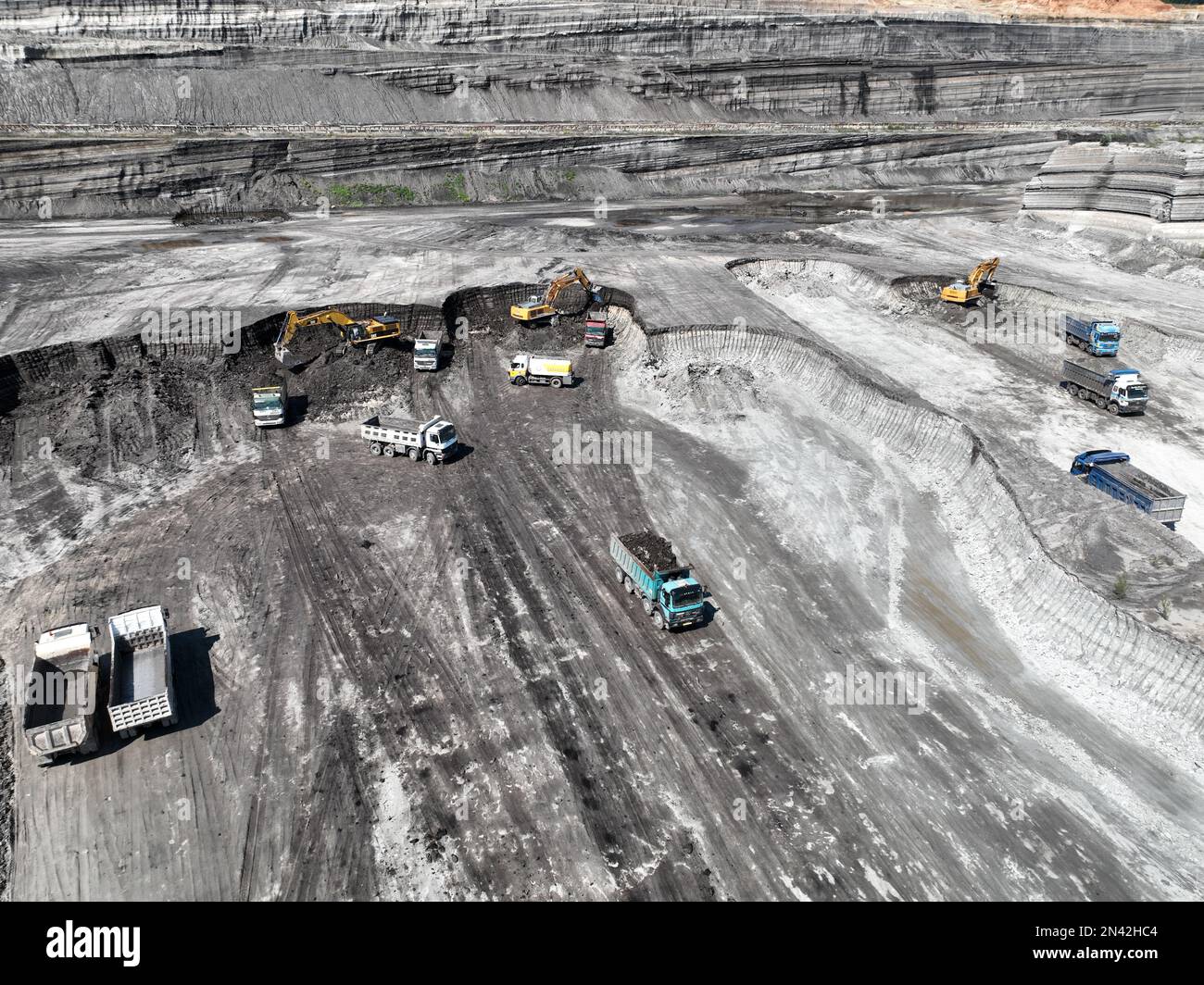 Excavators working. Loading trucks on huge mining site Stock Photo - Alamy