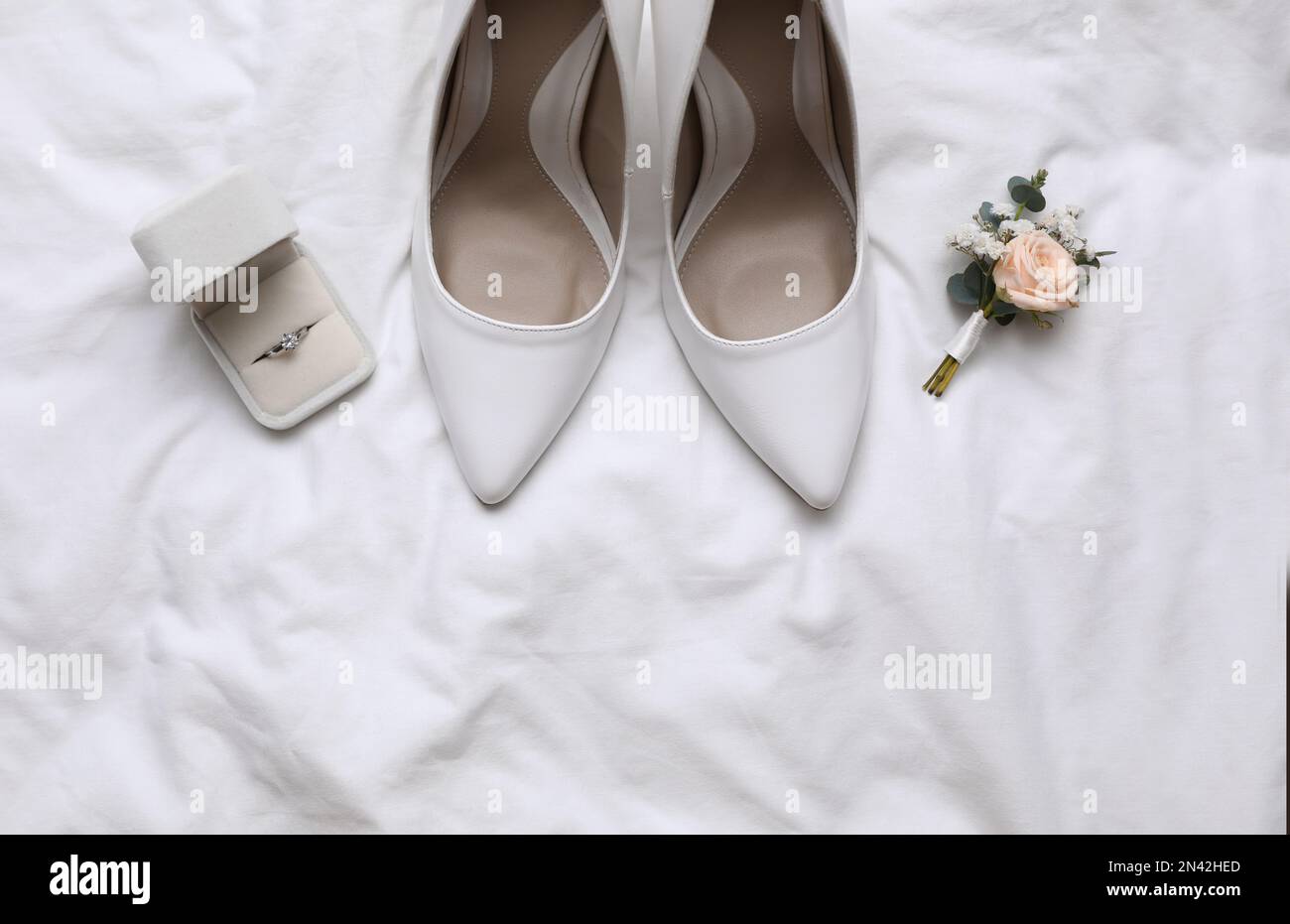 Flat lay composition with wedding high heel shoes on white fabric ...