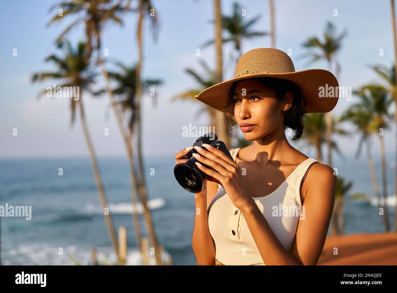 Young african female model tourist with camera in colorful clothes and ...