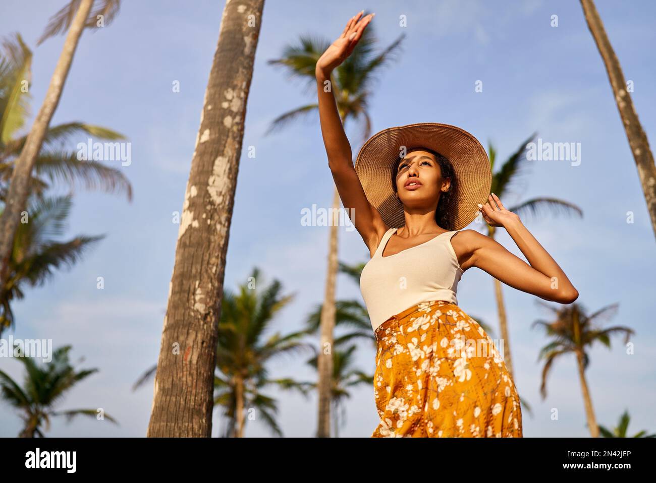 Young african female model posing in colorful clothes at tropical ...